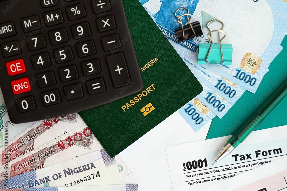 Nigerian naira money bills and calculator with tax form on flag ...