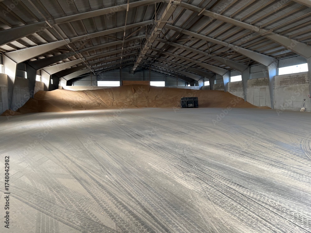 Large industrial warehouse with concrete floor and bulk grain storage ...