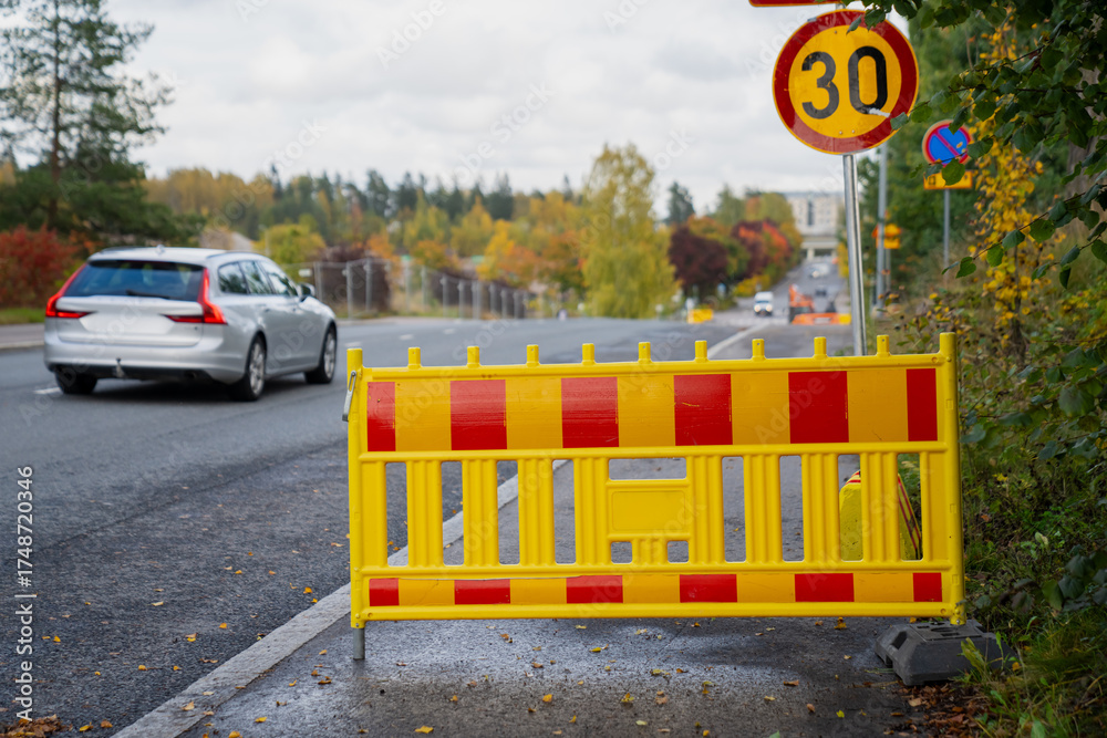 Road construction barrier with 30 km per hour speed limit sign on urban ...