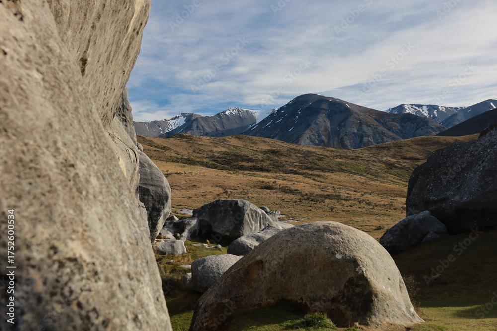 Dramatic limestone boulders, golden fields, and distant snow-capped ...