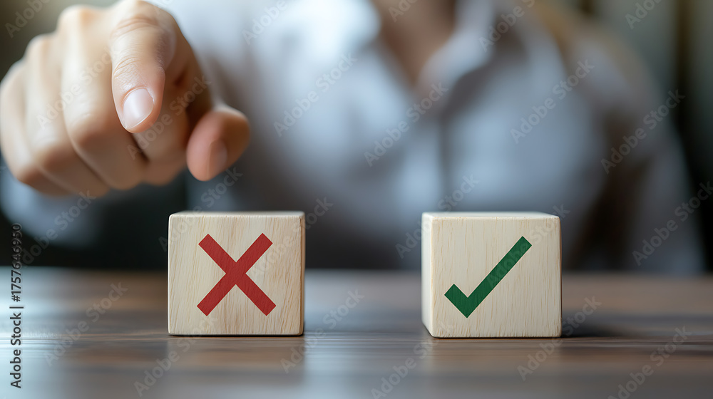 A person's finger points towards a wooden block with a green checkmark ...