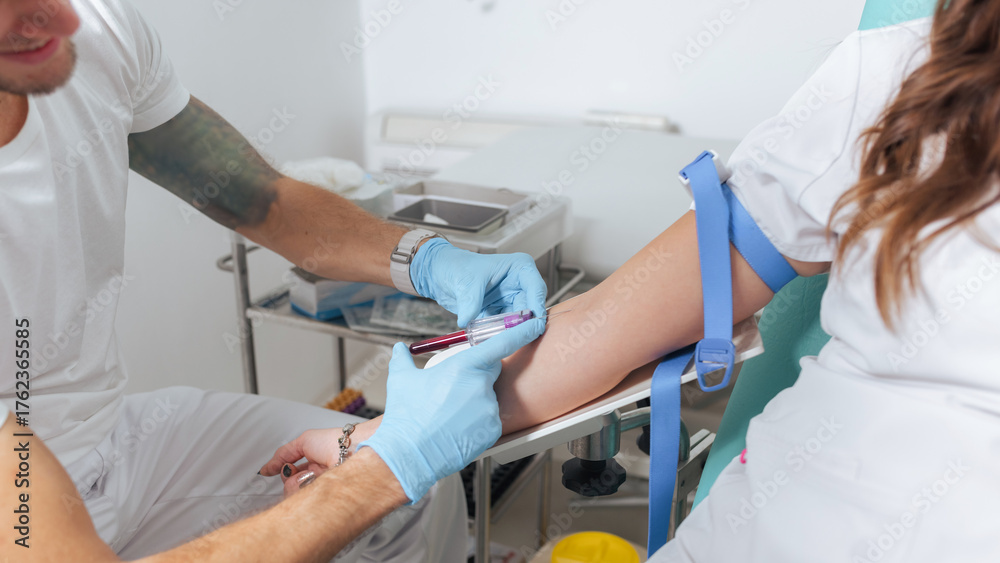 Zdjęcie bez tantiem: Lab professional taking a blood sample from a vein ...