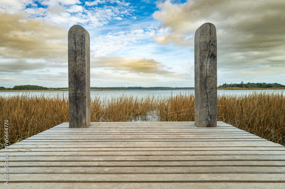 Newly built timber jetty seen extending to a large lake and nature ...
