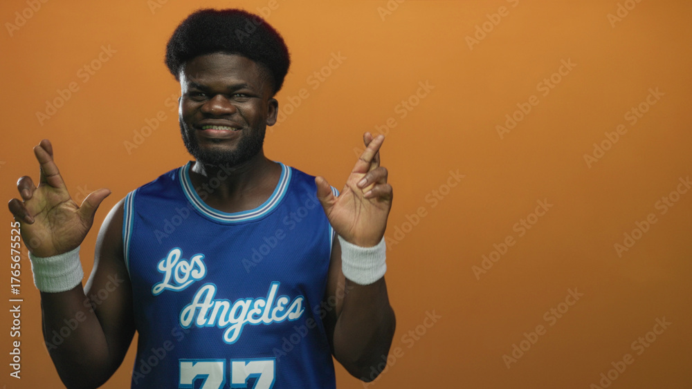 Man with hands pressed together in praying gesture wearing blue los ...