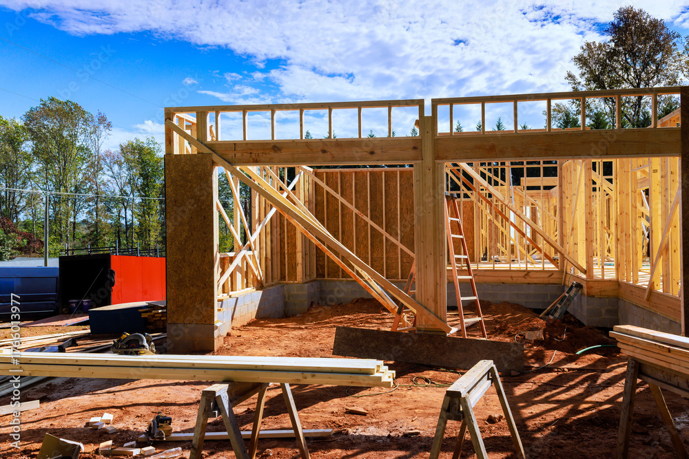 Construction progresses under work day with wooden beam framing in ...