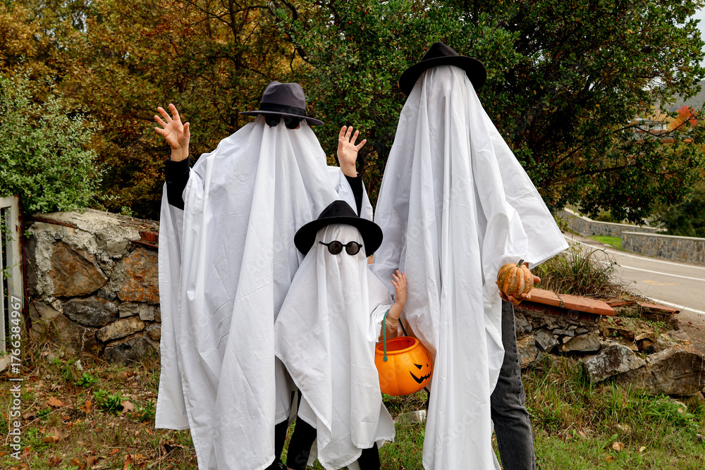 A family dressed up as ghosts. Mom, dad, and child in ghost costumes ...