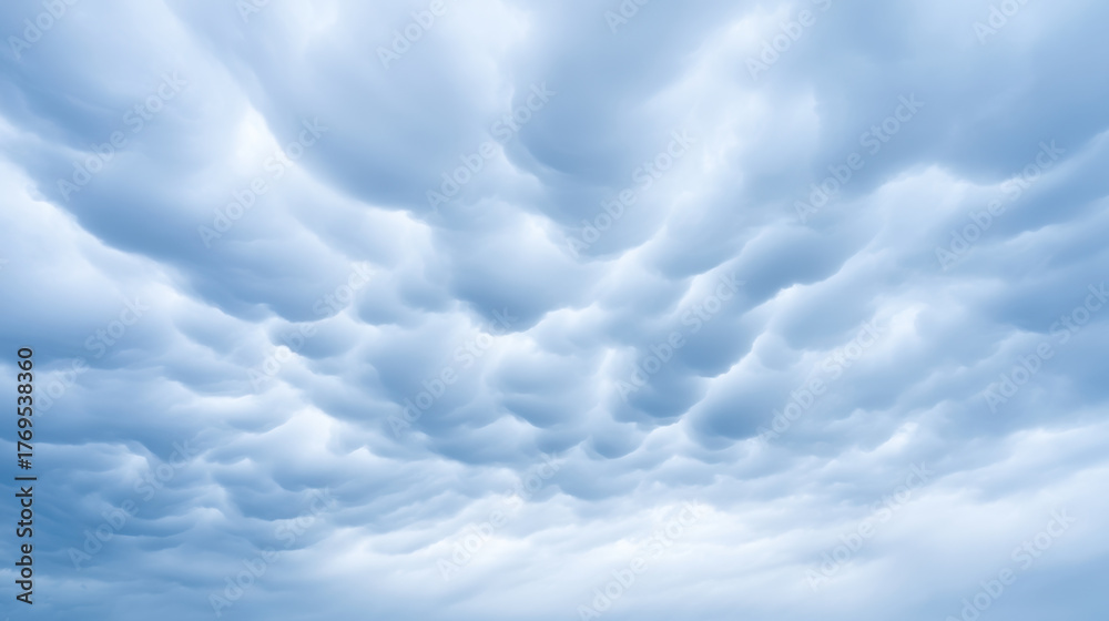Mammatus cloud formation with unusual rounded shapes in blue sky ...