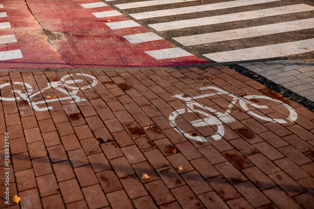 Bike lane and crosswalk markings on red brick pavement. A bike lane and ...