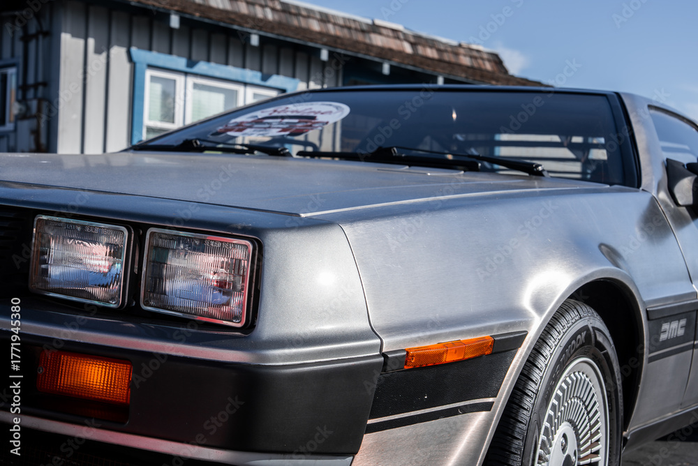 Stainless steel DeLorean DMC 12 parked by a coastal style building in ...