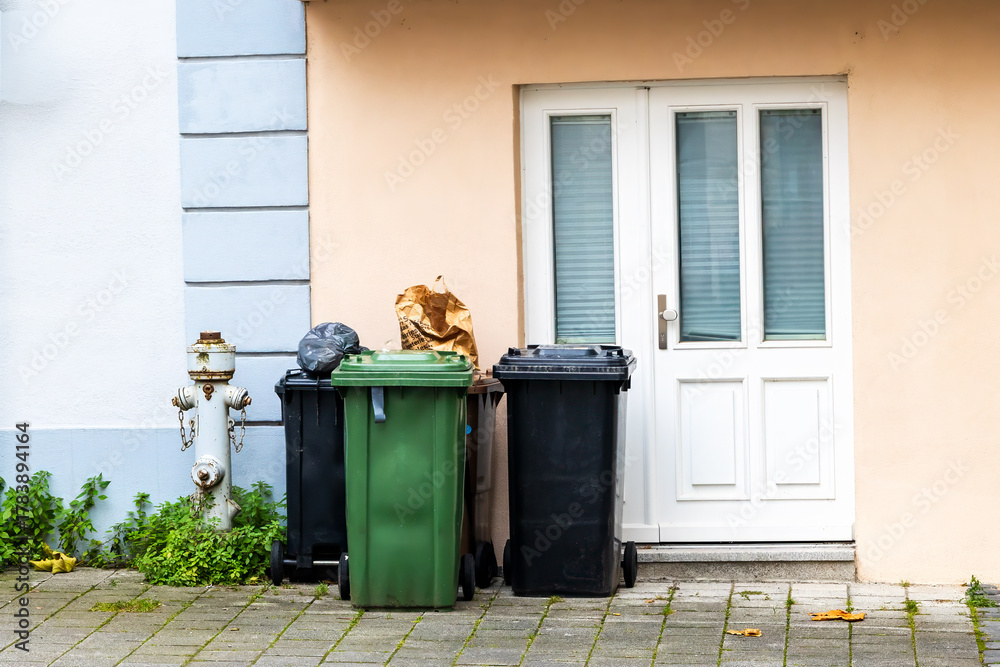 Residential entrance with waste bins and hydrant in front of pastel ...