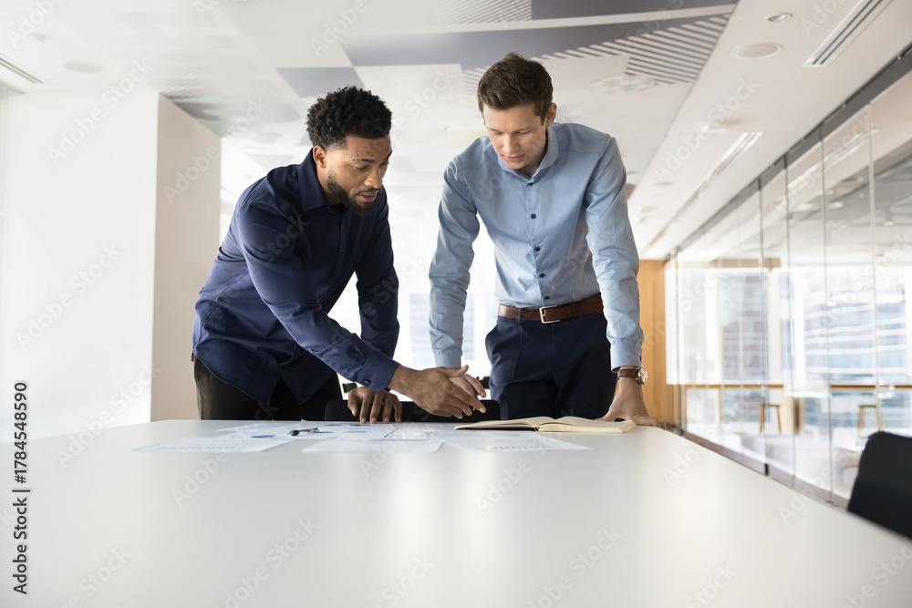 Two gen z workmates of diverse ethnicity collaborating at workplace ...