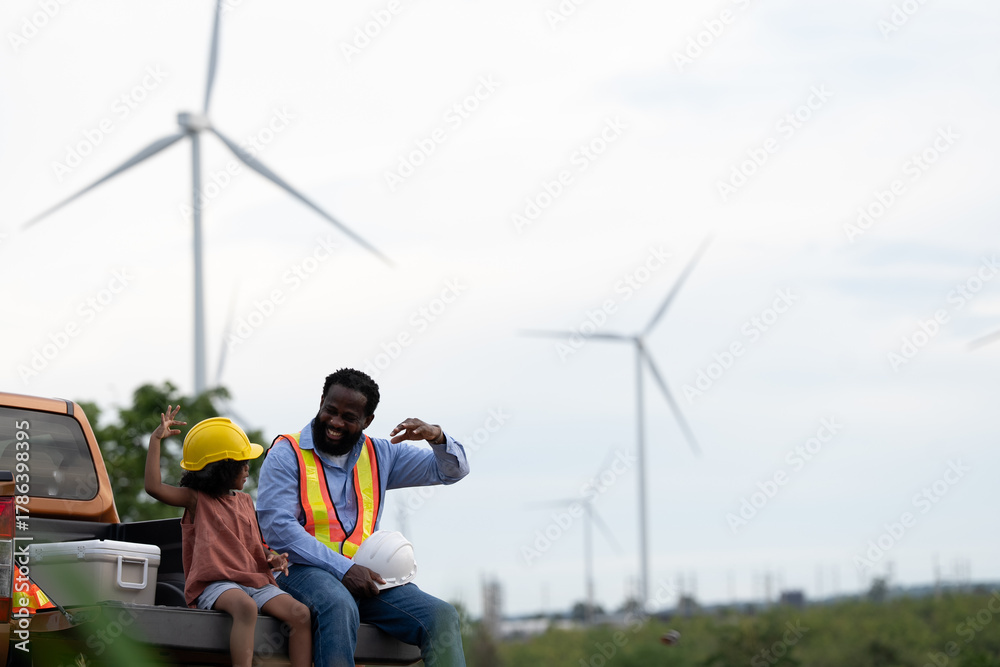 Engineer father and daughter celebrating at wind turbine site, raising ...