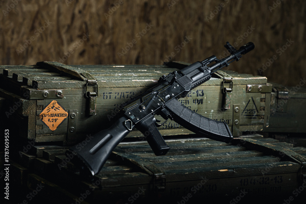 assault rifle placed on identified ammunition box displaying hazard and ...