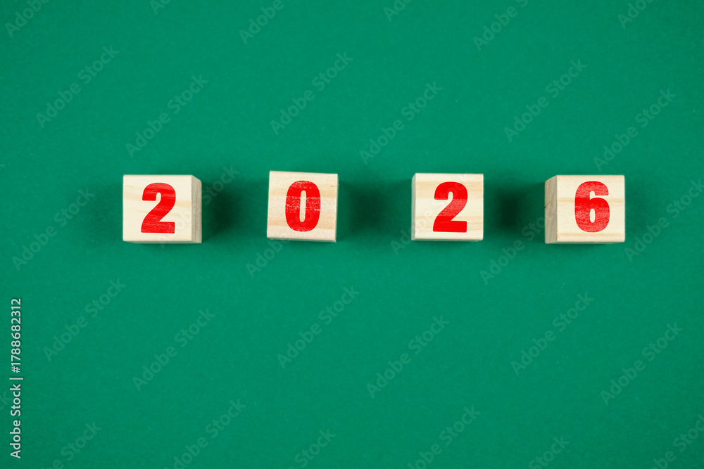 Photo Stock Wooden cube block for 2026 on green background. New year ...