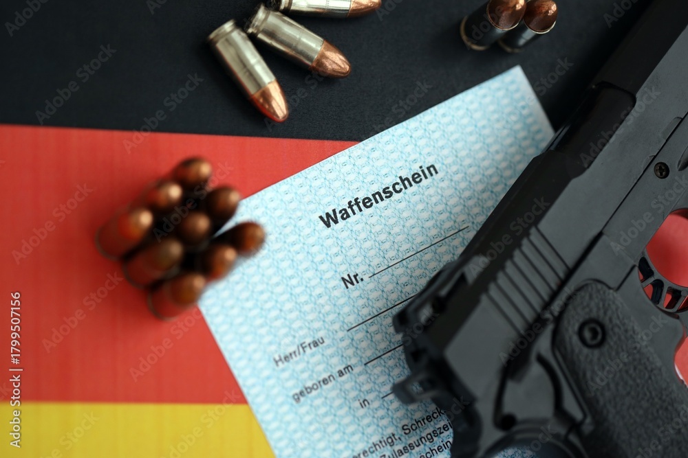 German firearms license and handgun with bullets on Germany flag close ...