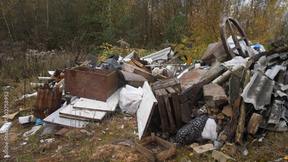 pile of corrugated sheets and debris scattered near forest edge; rusted ...
