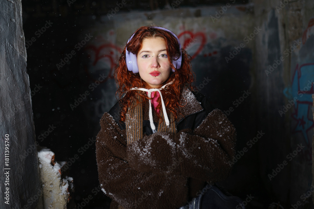 Stock-Foto „Red haired young woman wearing headphones in winter near ...