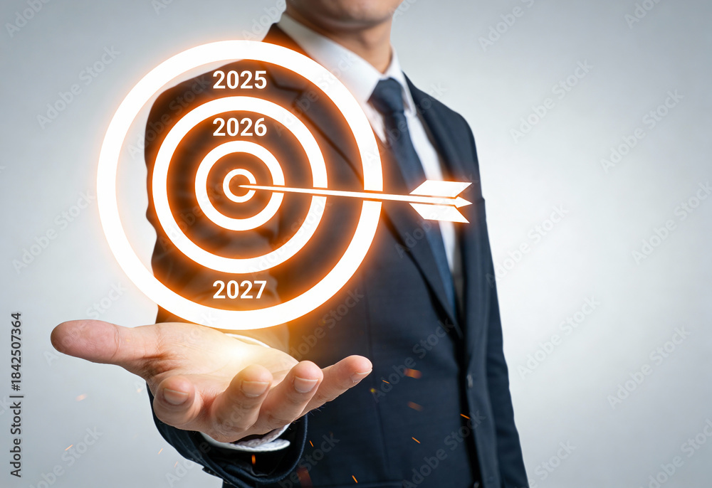 Businessman presenting yearly goals for 2026 with a glowing target and ...