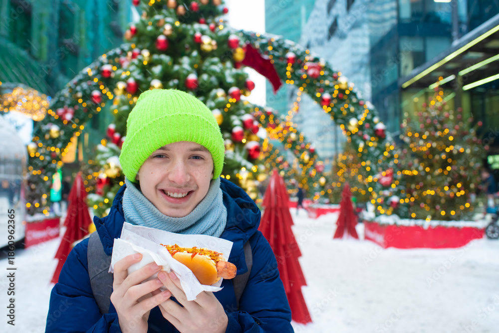 Photo Stock Teenage boy holding hot dog with crispy onions in bun on ...
