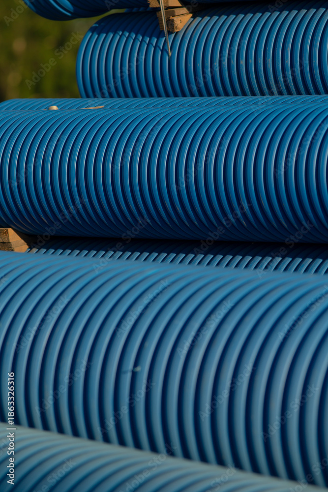 Rows of blue drainage pipes in depot organized for inventory and ...