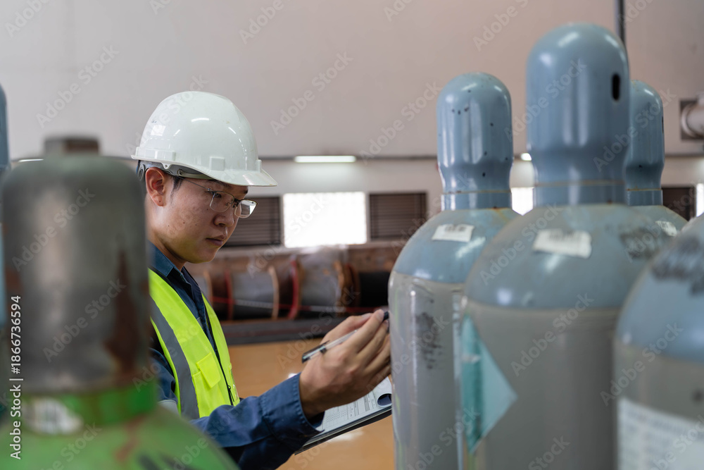 Engineer auditing gas cylinders in a substation warehouse, verifying ...
