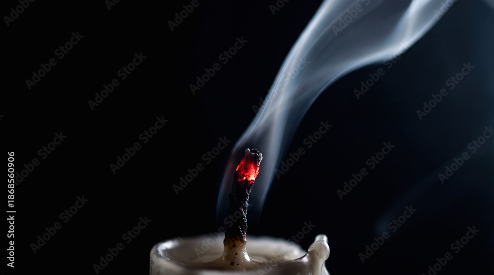 Extinguished candle with smoke trail and glowing red wick on black ...