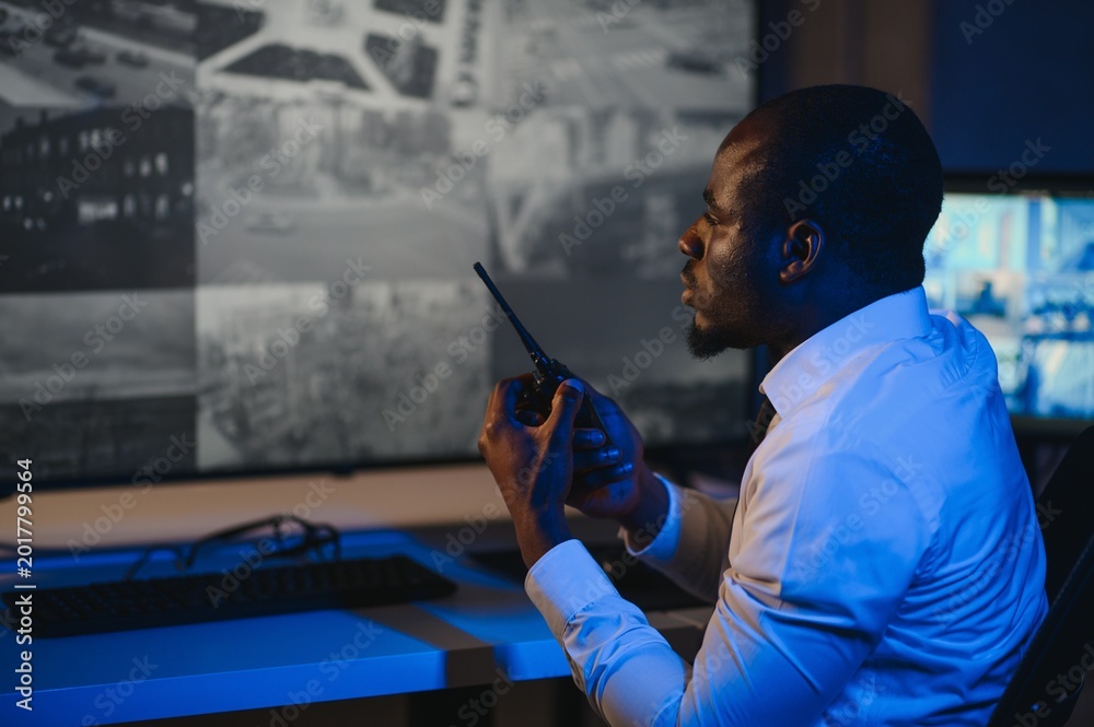 African American security guard looking at desktop computer screen ...