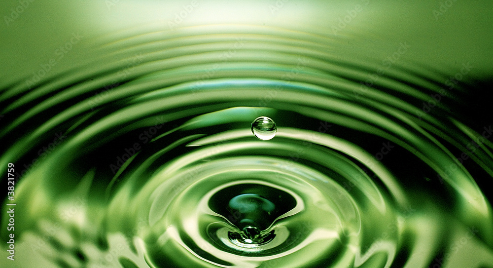 single water drop about to splash into a green pool of water below that ...