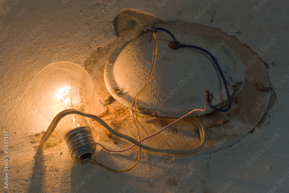 Lit electric bulb, soldered to wires, on wall. Shallow depth Stock ...