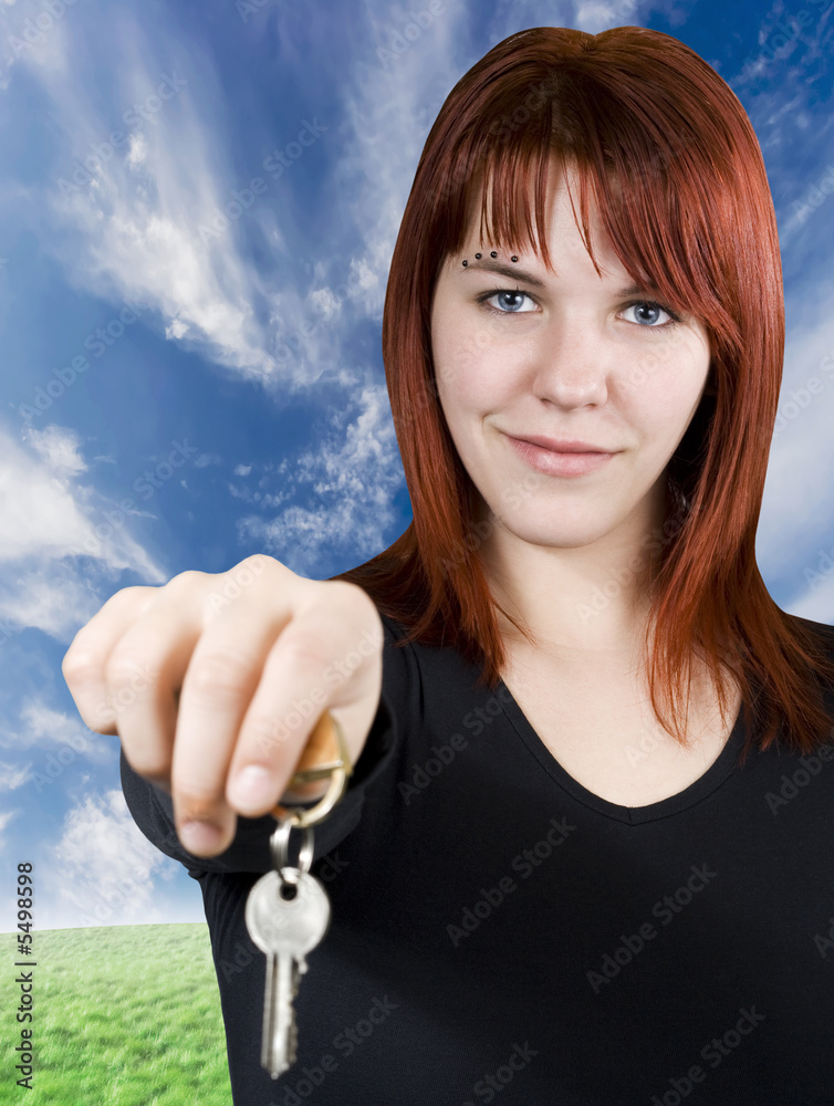 Cute smiling redhead girl holding keys towards the camera Stock 写真 ...