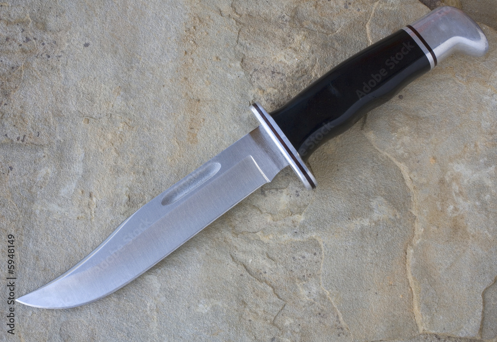 long hunting knife that's a fixed blade style outdoors on a rock Stock ...