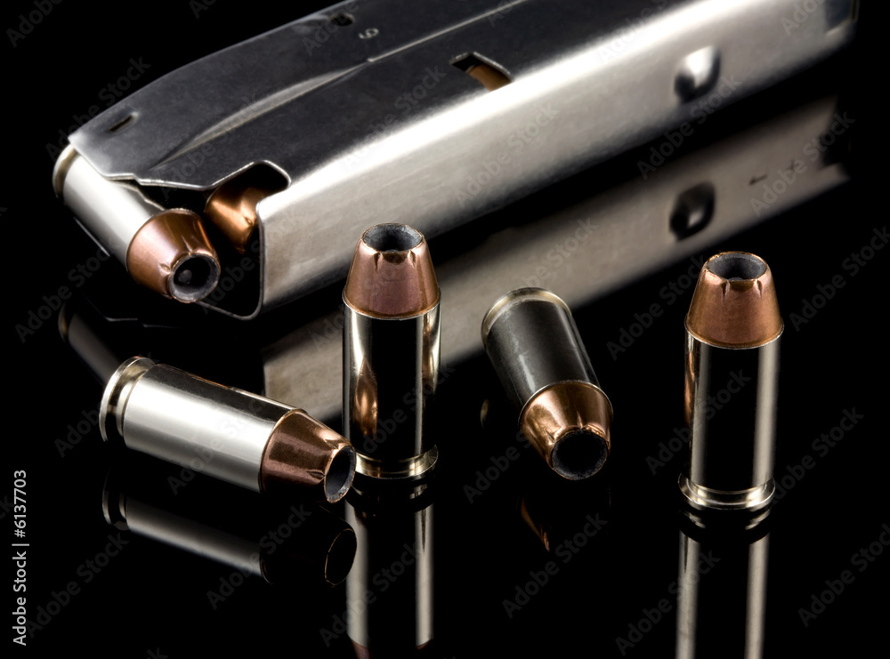 40 caliber bullets and clip on reflective black background Stock Photo ...
