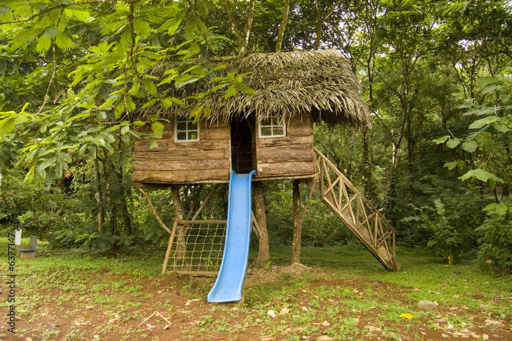 Small tree house with slide Stock Photo | Adobe Stock