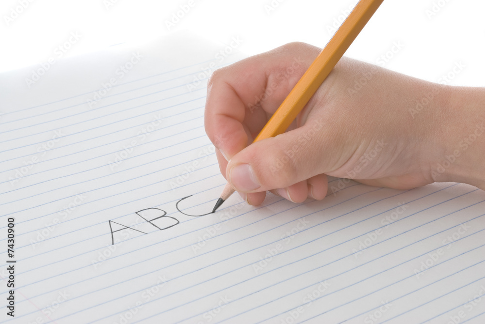 Child's hand holding pencil, writing alphabet on paper Stock Photo ...