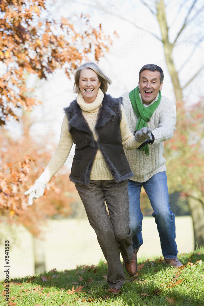 Senior man chasing woman through countryside Stock Photo | Adobe Stock