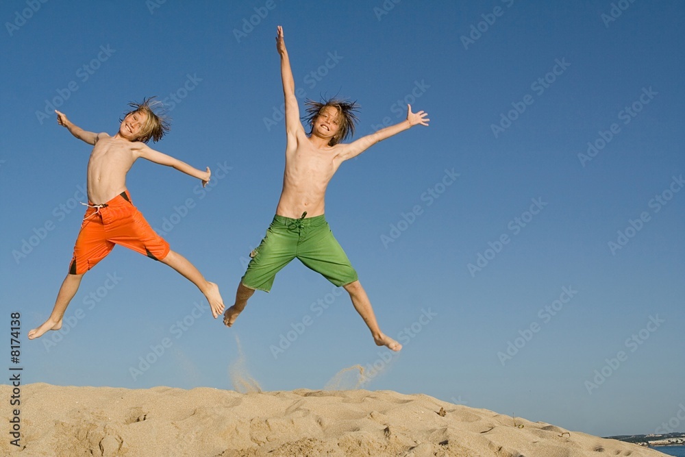 happy children jumping for joy on summer beach vacation Stock Photo ...