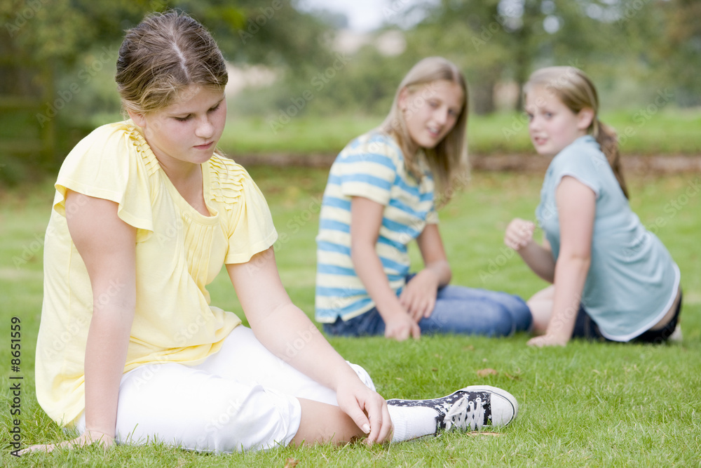 Two young girls bullying other young girl outdoors Stock Photo | Adobe ...