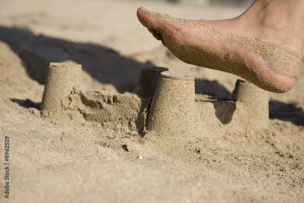 A sand castle at the beach about to be destroyed by a foot Stock Photo ...