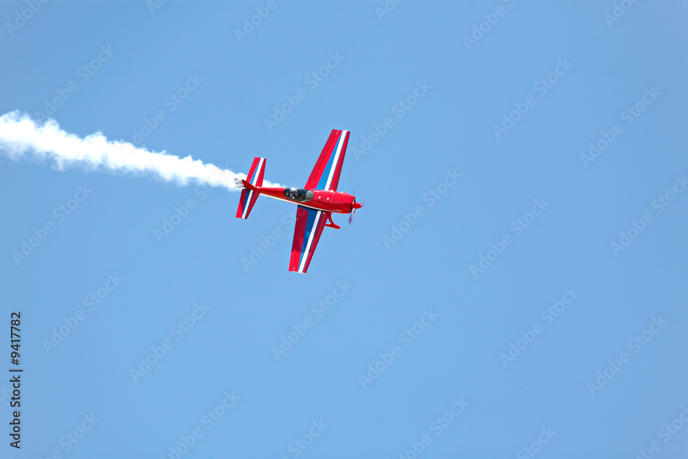 aerial acrobatics - red propeller plane with smoke blue sky Stock Photo ...
