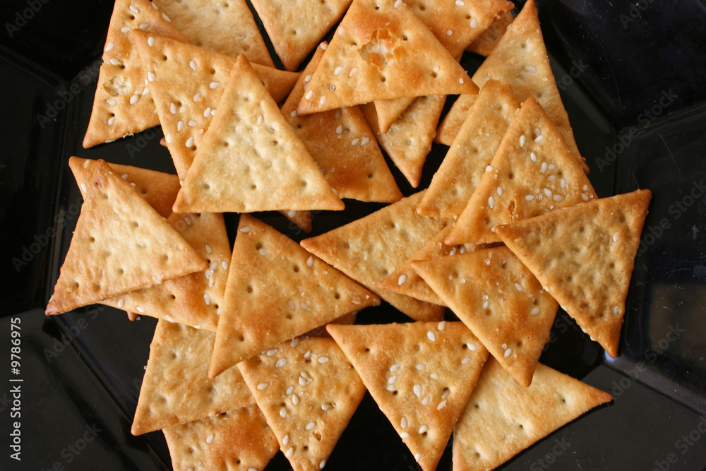 Gold triangle crackers on decorate plate. Stock Photo | Adobe Stock