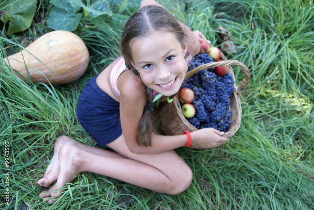Preteen girl with basket full of organic grapes and apples Stock-Foto ...