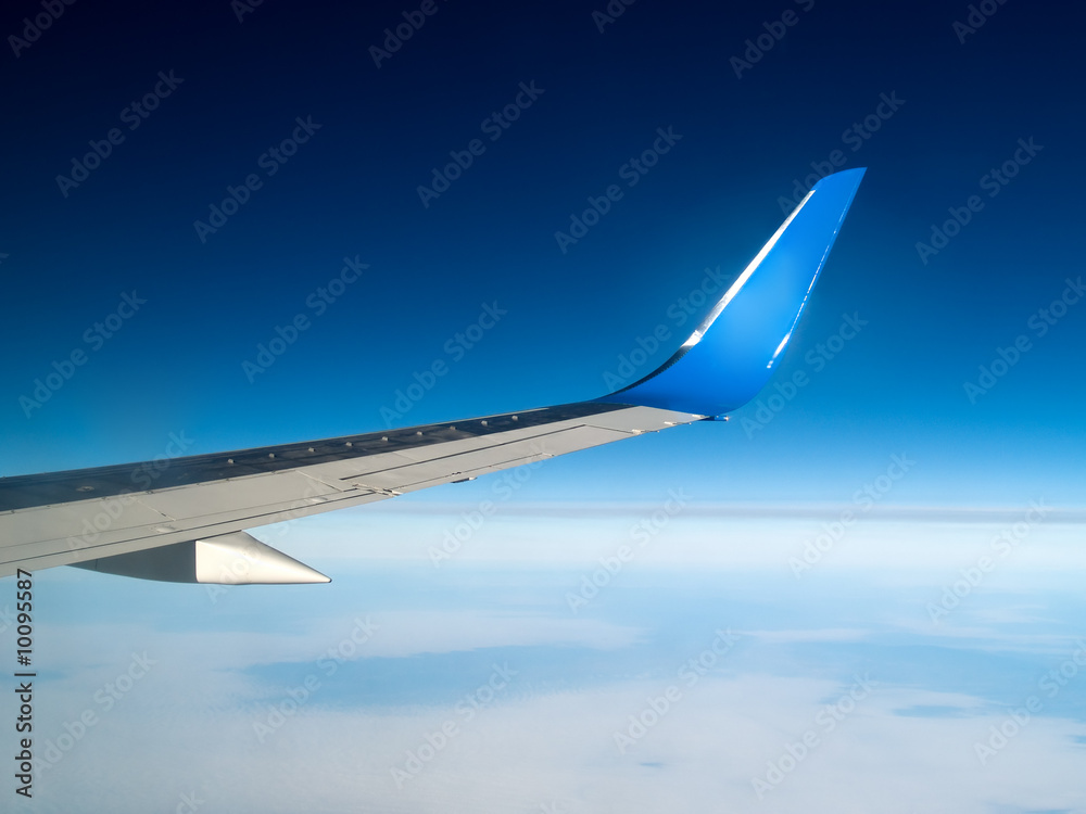 Airliner wing and skies mid-air from illuminator Stock Photo | Adobe Stock