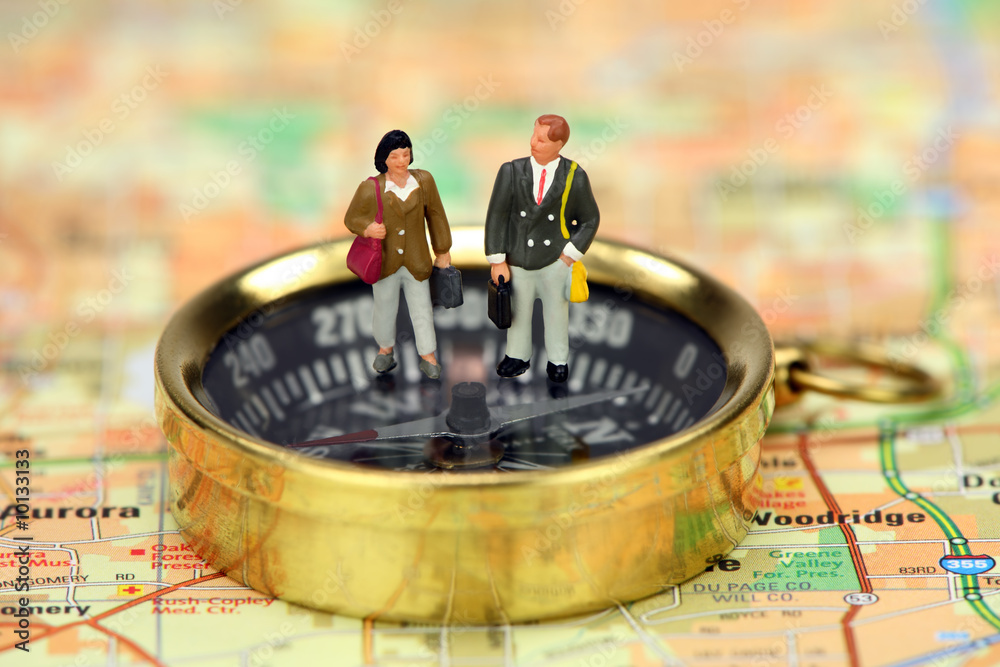 Miniature business travelers standing on a compass on a map Stock Photo ...