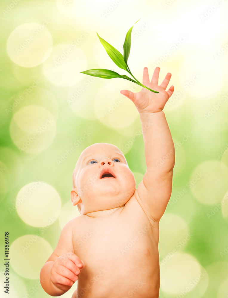 Beautiful baby trying to catch green leaf Stock Photo | Adobe Stock