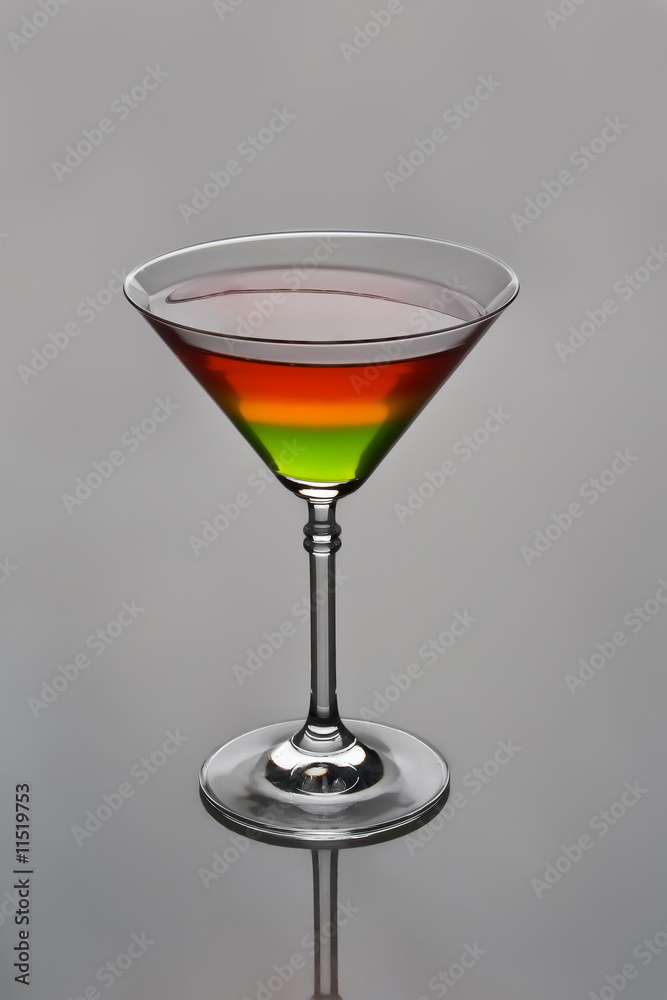 Glass of tricolor cocktail on grey foto de Stock | Adobe Stock