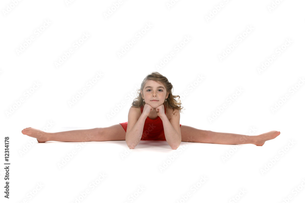 young girl doing a split with her hands under her chin Photos | Adobe Stock