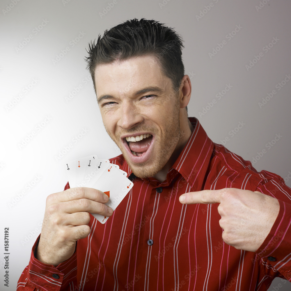 homme content tenant un carré d'as Photos | Adobe Stock