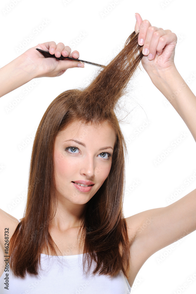young brunette girl doing backcombing with comb Stock Photo | Adobe Stock