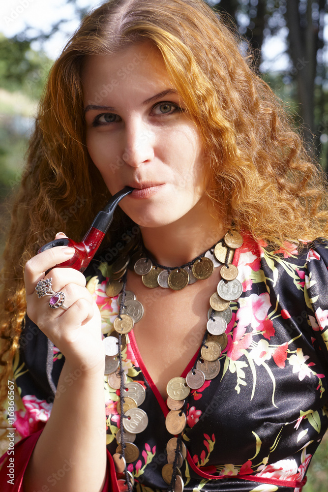 A beautiful ginger-haired girl in gypsy suit with pipe Stock Photo ...