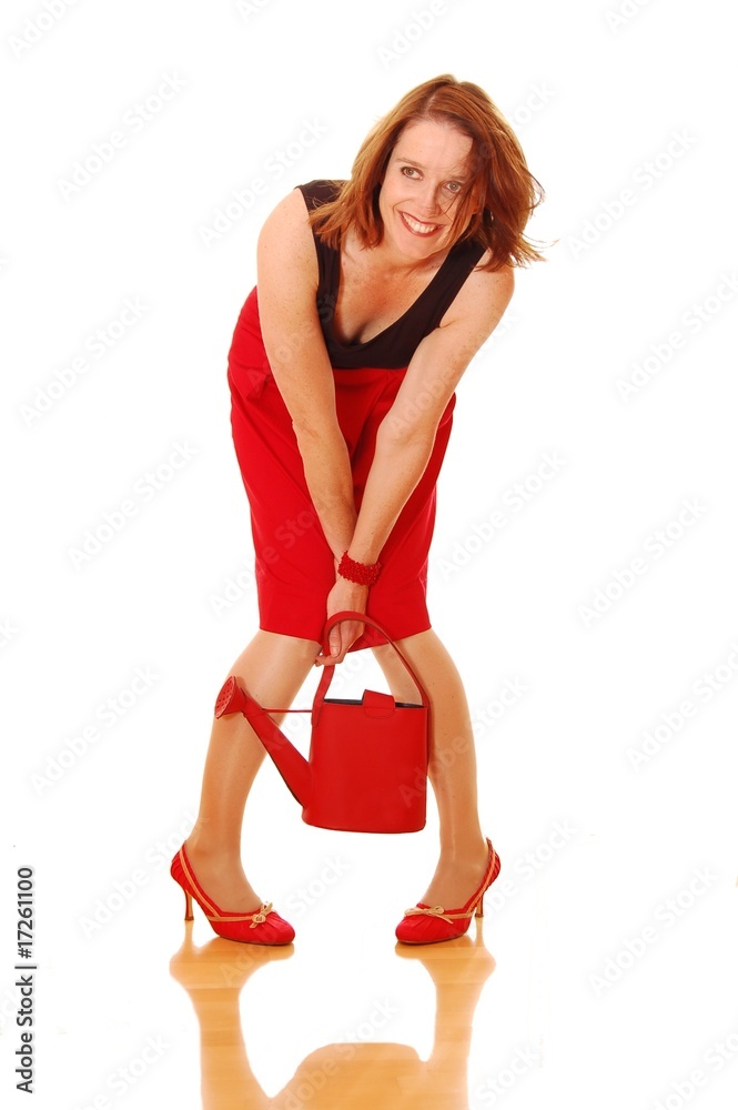 Hübsche Frau mit rotem Rock und Gießkanne Stock Photo | Adobe Stock